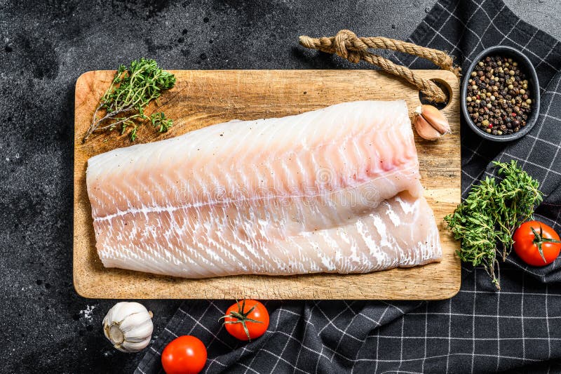 Raw Cod Fillet with and Herbs on Rustic Wooden Cutting Board. Black ...