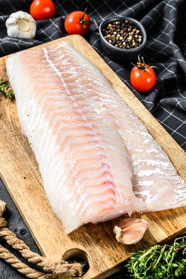 Raw Cod Fillet with and Herbs on Rustic Wooden Cutting Board. Black ...