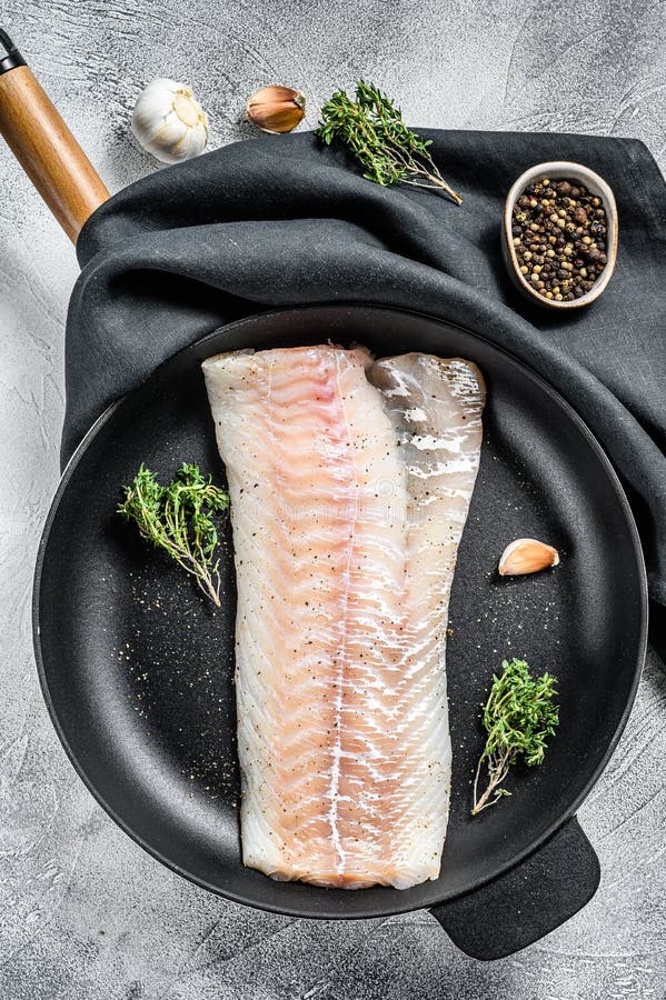 Raw Cod Fillet with and Herbs on Rustic Wooden Cutting Board. Black ...