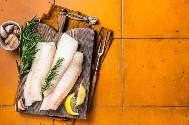 Raw Cod Fish Fillets, Codfish with Rosemary on Wooden Board. Orange ...