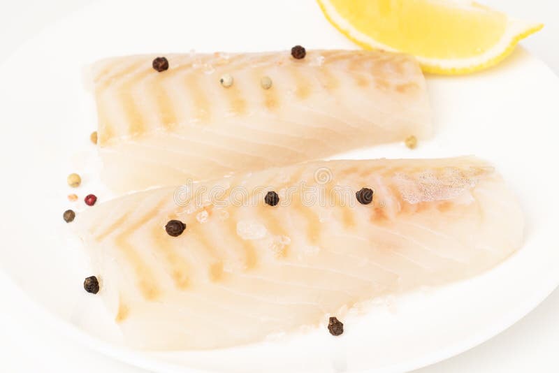 Raw Cod Fish Pieces on the Plate Spiced with Salt, Peppercorns and ...