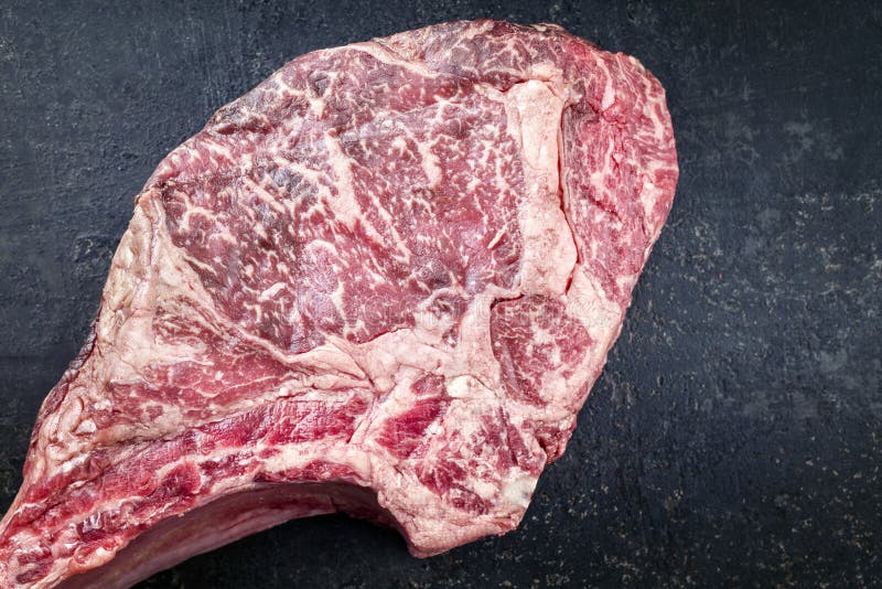 Raw Dry Aged Wagyu Tomahawk Beef Steak on an Old Rustic Board Stock ...