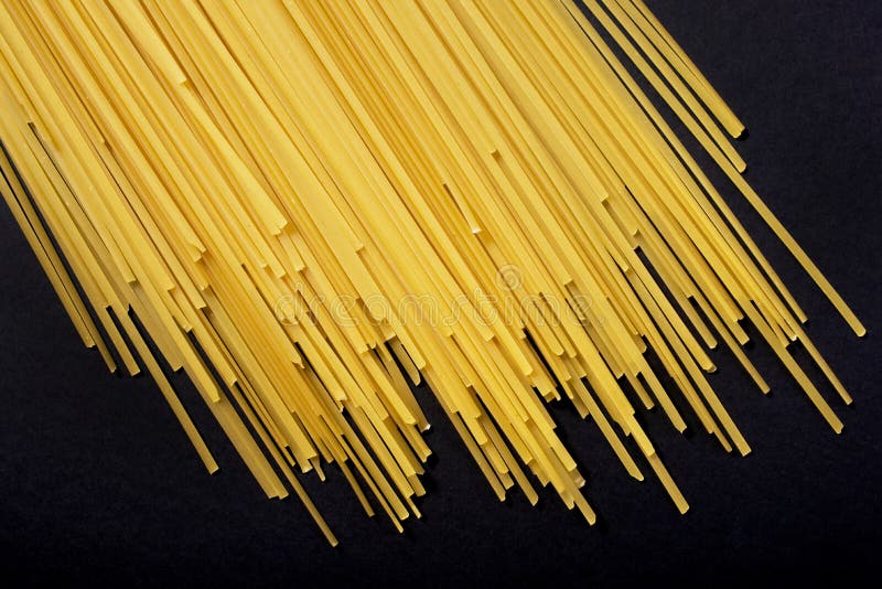 Raw Flat Spaghetti on Black Background Stock Photo - Image of ...