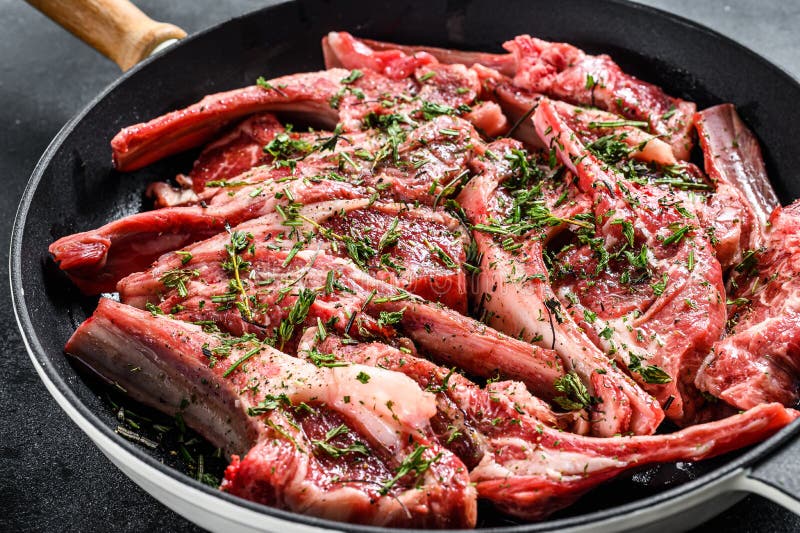 Raw Fresh Lamb Rib Chops Marinated with Thyme and Mint in a Pan. Black ...