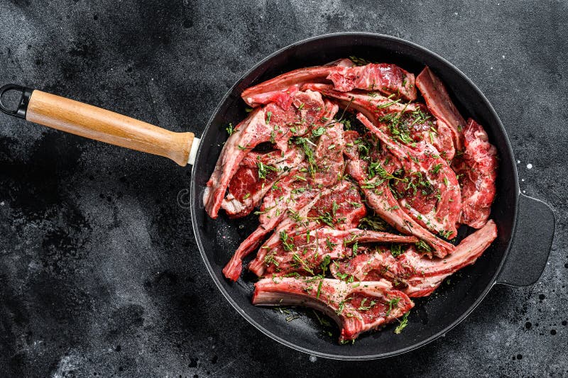 Raw Fresh Lamb Rib Chops Marinated with Thyme and Mint in a Pan. Black ...
