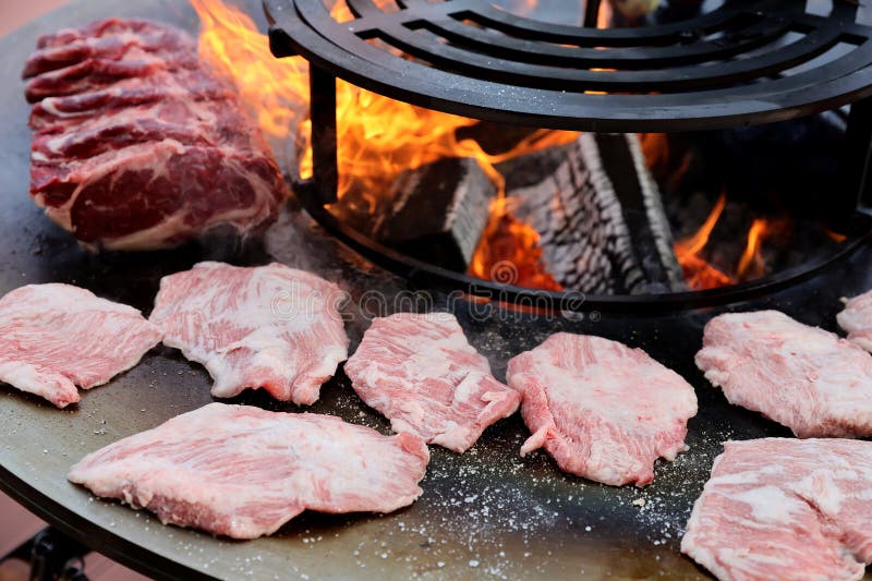 Raw Fresh Pieces of Meat are Placed on a Cast Iron Grill To Be Grilled ...