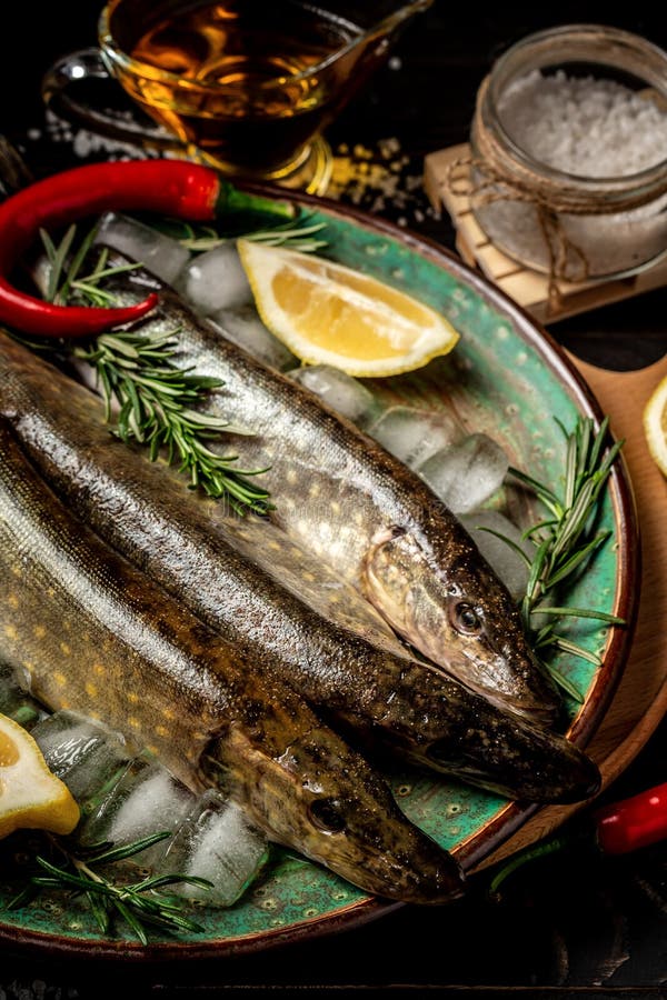 Raw Fresh River Fish Fish on Plate Cutting Board. Fish, Lemon, Herbs ...