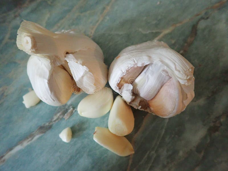 Raw garlic on a table stock photo. Image of background - 264502836