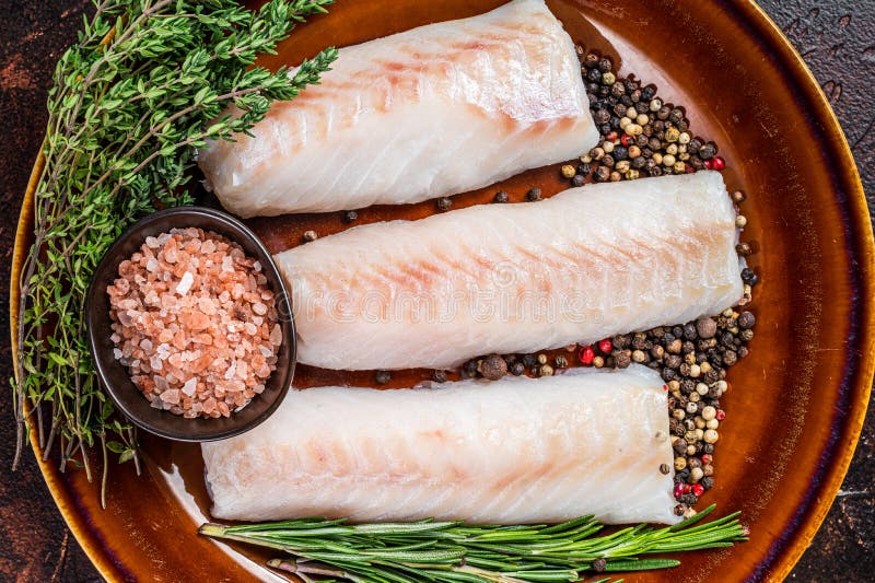 Raw Haddock Loin Fillet Fish on Rustic Plate with Thyme and Salt. Dark ...