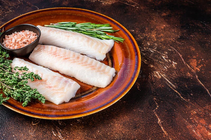 Raw Haddock Loin Fillet Fish on Rustic Plate with Thyme and Salt. Dark ...