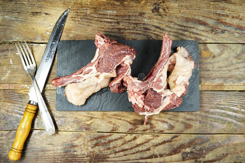 Raw Lamb Chops on a Dark Board on Wood Table Stock Photo - Image of ...