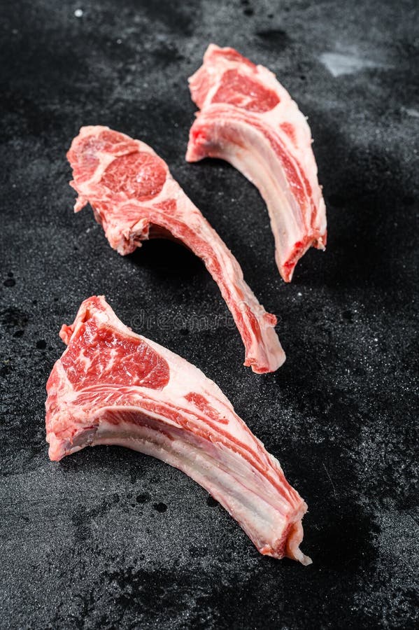 Lamb Chops Raw Meat on Bone with Salt, Pepper and Herbs. Black Wooden ...