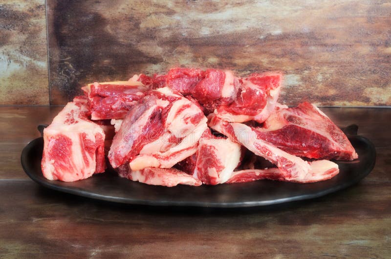 Raw Meat with Bone on Clay Plate and Brown Stone Background.Raw Meat ...
