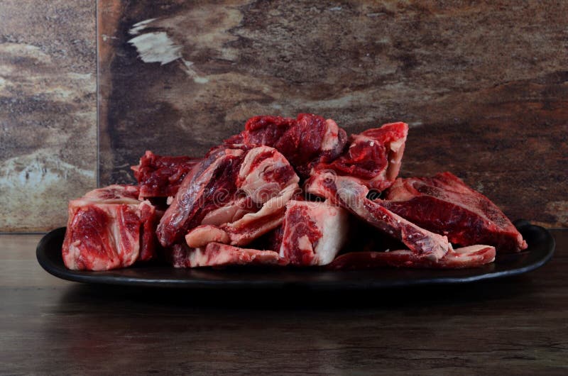 Raw Meat with Bone on Clay Plate and Brown Stone Background.Raw Meat ...