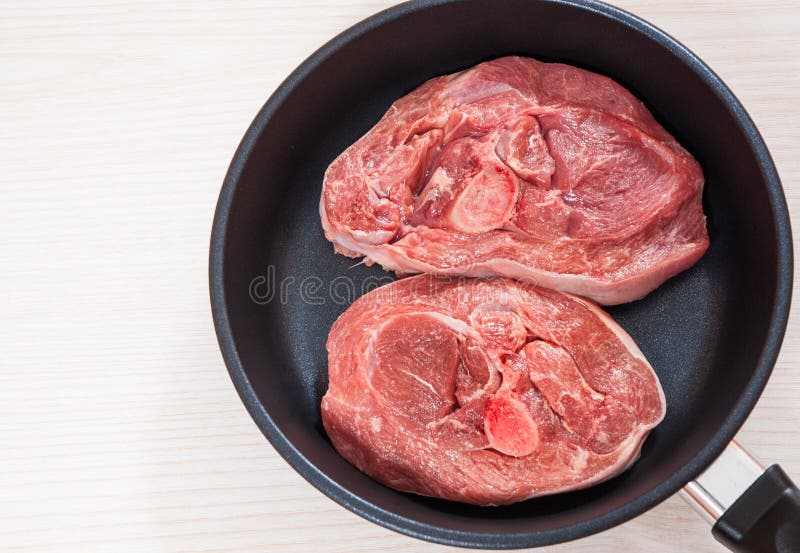 Raw meat in a frying pan stock photo. Image of cooking - 60302696