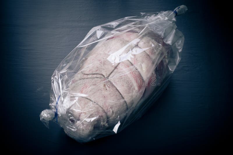 Raw Meat with Rope in the Package on a Black Background. Toned Stock ...