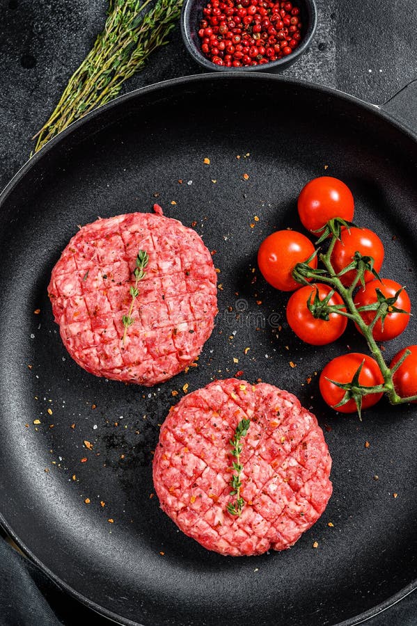 Raw Minced Marble Beef Meat Cutlets in a Pan. Black Background Stock ...