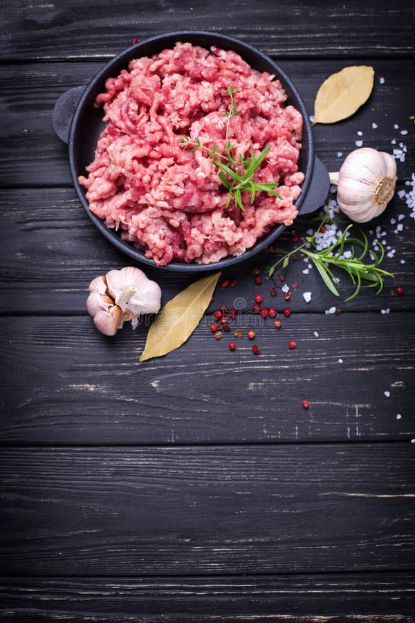 Raw Minced Meat in Bowl with Ingredients for Cooking on Black Stock ...