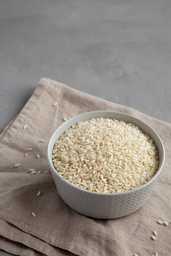 Raw Organic Carnaroli Rice in a Bowl on a Gray Background, Side View ...