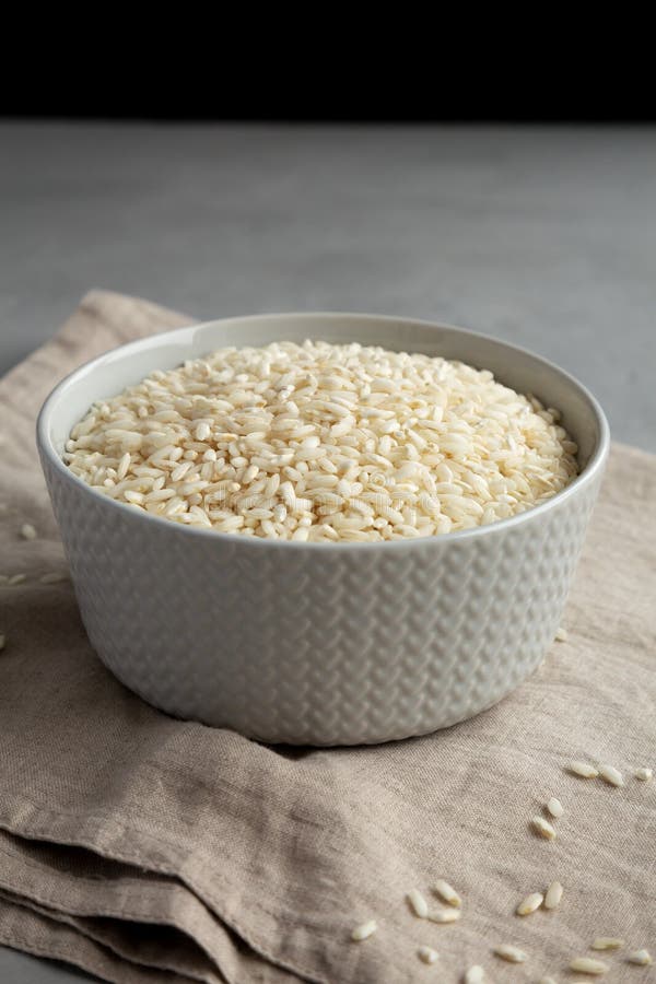 Raw Organic Carnaroli Rice in a Bowl on a Gray Surface, Side View Stock ...