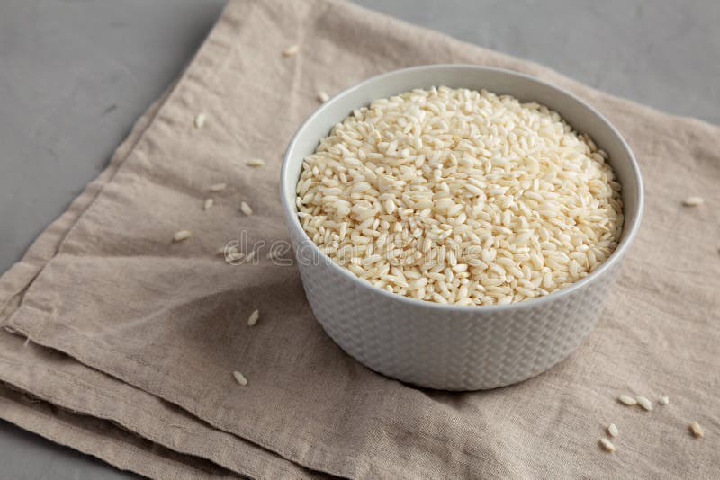 Raw Organic Carnaroli Rice in a Bowl on a Gray Surface, Side View ...
