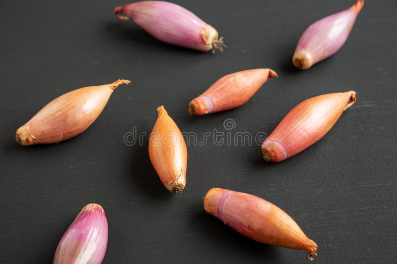 Raw Organic Shallots on a Black Surface, Side View Stock Photo - Image ...