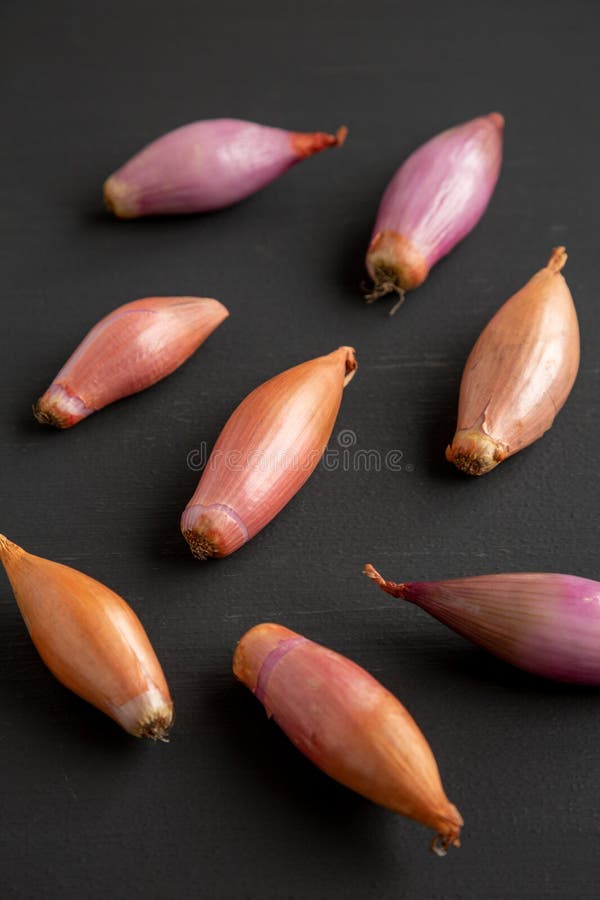 Raw Organic Shallots on a Black Surface, Side View Stock Photo - Image ...