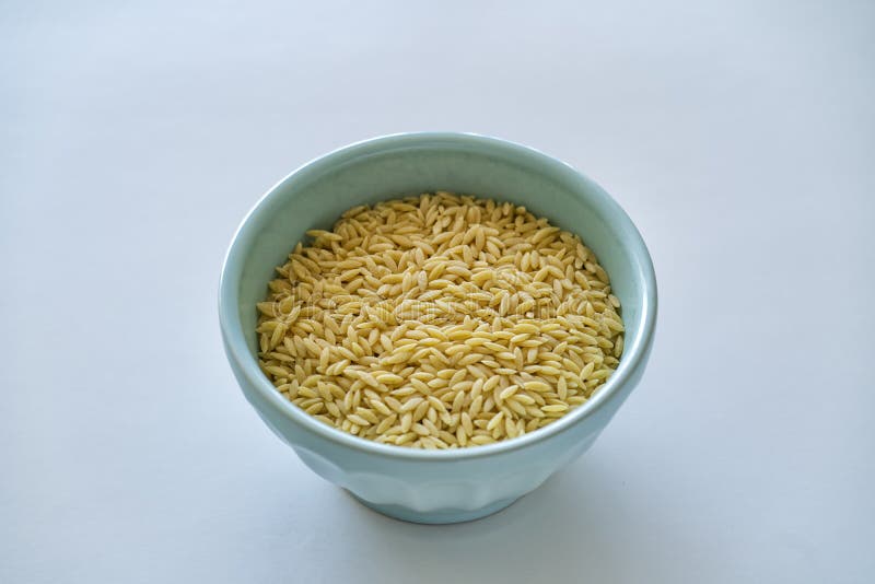 Raw Orzo in a blue bowl stock image. Image of grain - 198073669