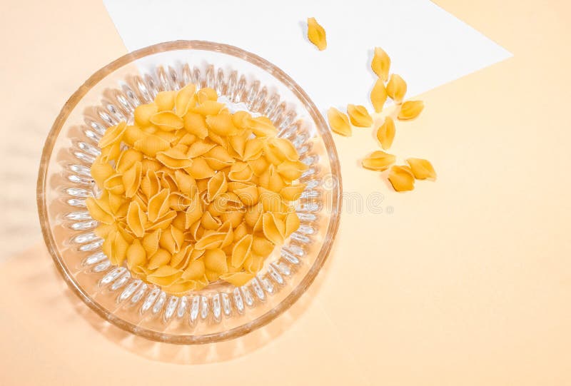Raw Pasta in the Form of Shells in a Glass Cup Stock Photo - Image of ...