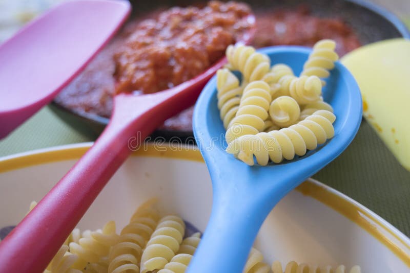 Raw Pasta and Tomato Sauce on Two Plastic Ladles Stock Photo - Image of ...