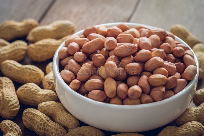 Raw Peanuts in White Bowl and Peanut Shell on Wooden Table Stock Photo ...