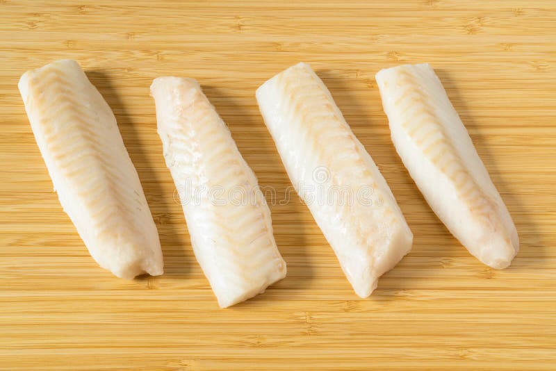 Raw Pieces of Frozen Cod Fish Loins on Wooden Cutting Board Stock Image ...