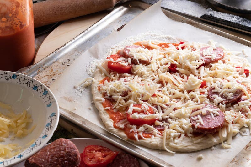 Raw Pizza, Preparation in Traditional Style. Adding Cheese on a Pizza ...