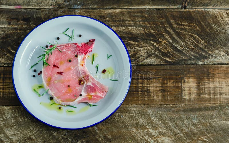 Raw Pork Chop in White Plate on Dark Background. Copy Space Stock Photo ...