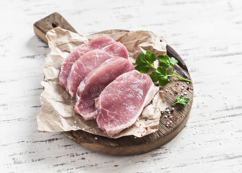 Raw Pork Chops on a Rustic Wooden Cutting Board Stock Photo - Image of ...
