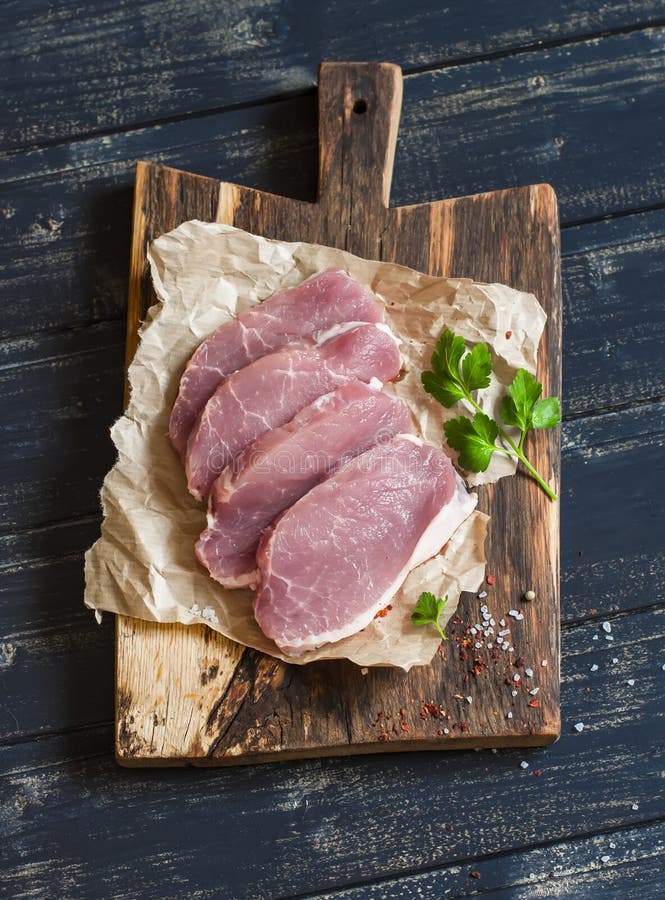Raw Pork Chops on a Rustic Wooden Cutting Board Stock Photo - Image of ...