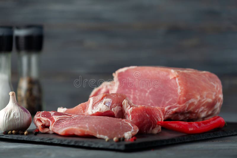 Raw Pork Meat. Fresh Steaks on Slate Board on Black Background. Side ...