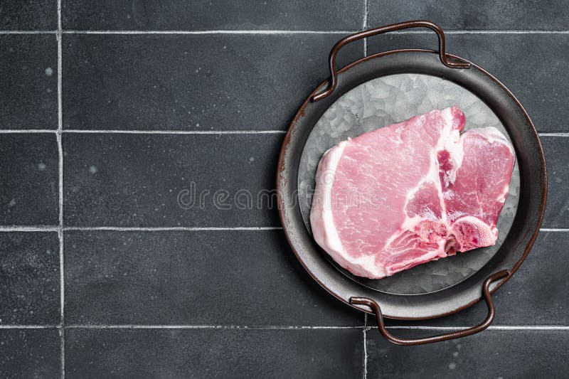 Raw Pork T Bone Chop Meat Steak. Black Background. Top View Stock Photo ...