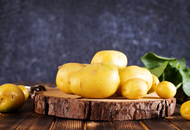 Raw potato on wooden board stock image. Image of carbohydrate - 336088161