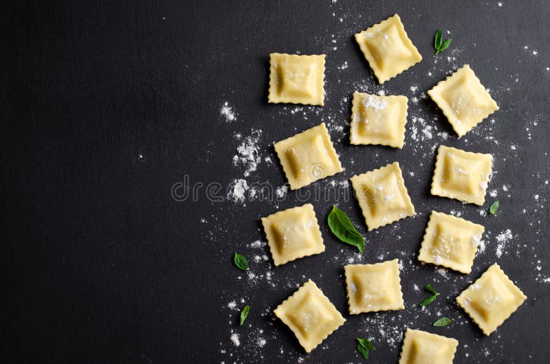 Raw Ravioli with Flour and Basil on Dark Background Stock Image - Image ...