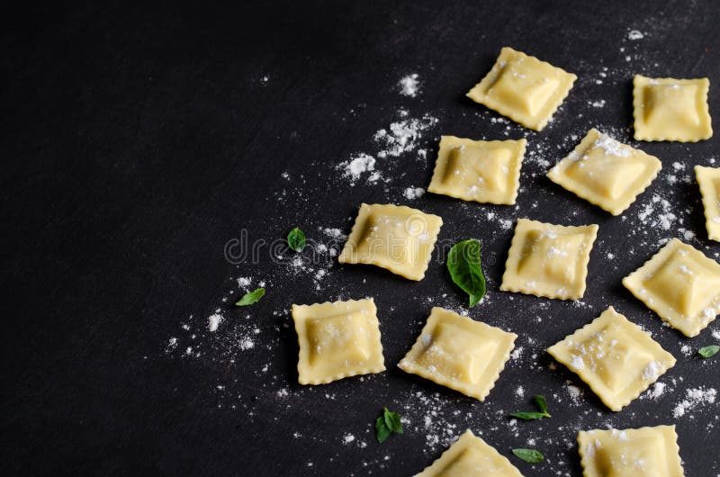 Raw Ravioli with Flour and Basil on Dark Background Stock Photo - Image ...