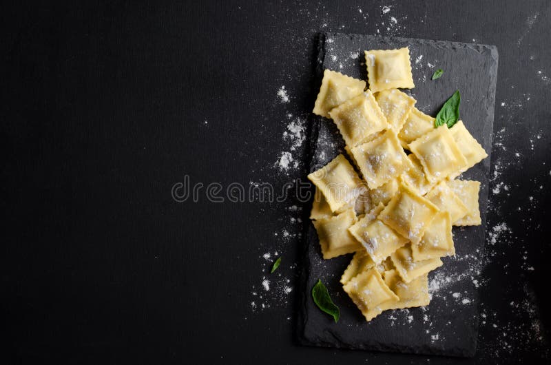 Raw Ravioli with Flour and Basil on Dark Background Stock Photo - Image ...