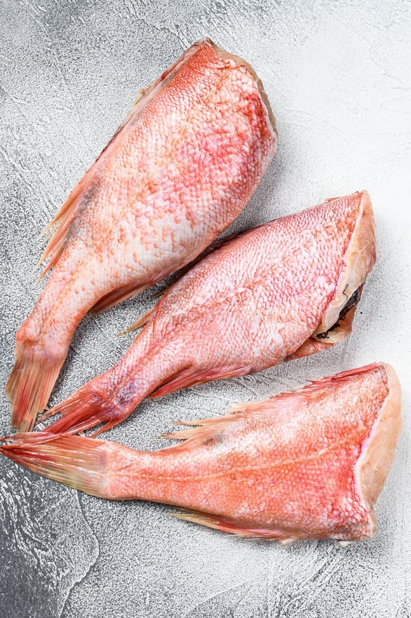 Raw Red Perch or Seabass Fish on a Cutting Board. Black Background ...