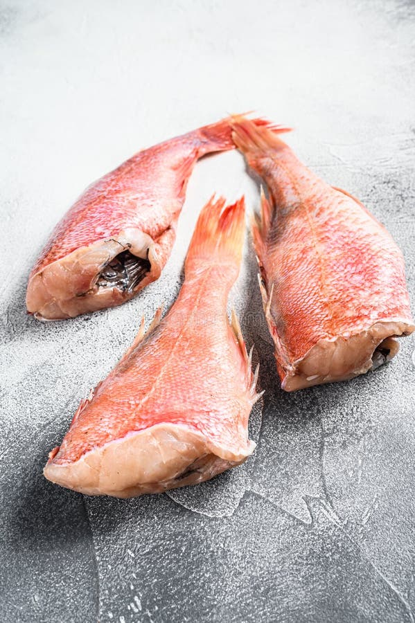Raw Red Perch or Seabass Fish on a Cutting Board. Black Background ...