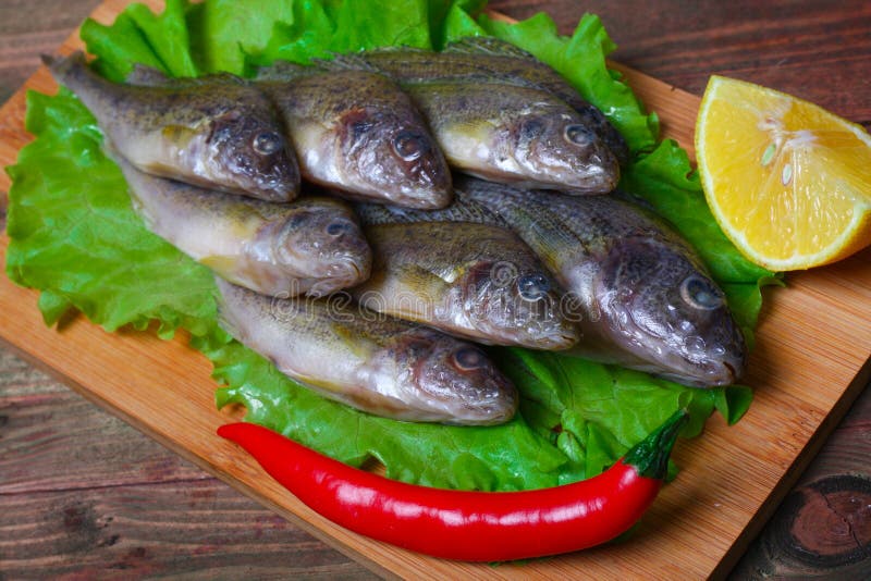 Raw Redfish Ruff Fish on the Kitchen Table with Vegetables and Lemon ...