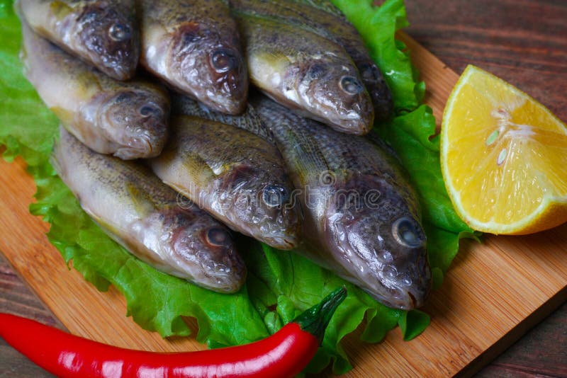 Raw Redfish Ruff Fish on the Kitchen Table with Vegetables and Lemon ...