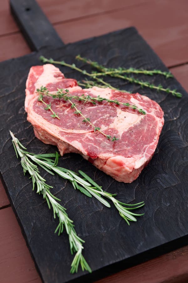 Raw Rib-eye Steak on Cutting Board Stock Photo - Image of prime ...