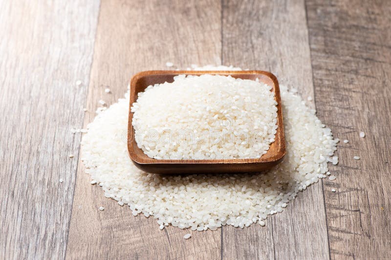 Raw rice in a wooden bowl stock photo. Image of dinner - 117775348
