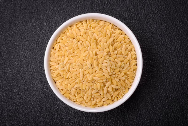 Raw Risoni Pasta Made from Durum Wheat on a Dark Concrete Background ...