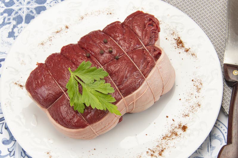 Raw roast beef on a plate stock photo. Image of roast - 231506322